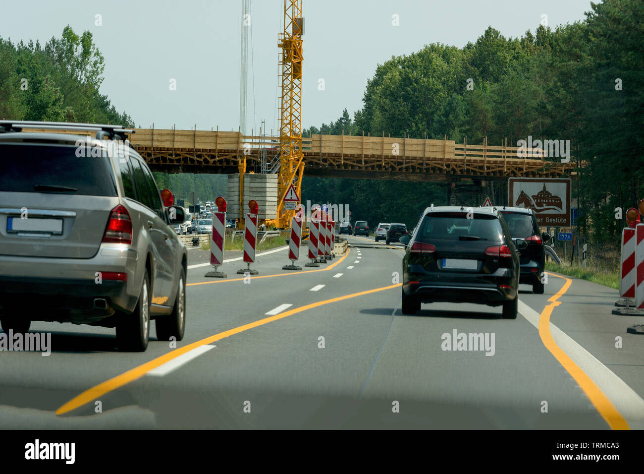 Various cars in a construction site area with construction crane on a ...
