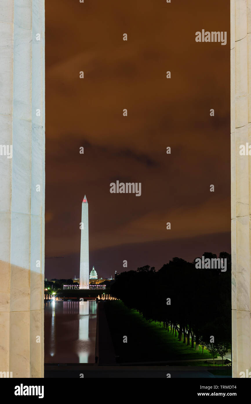 Reflecting Pool, Washington Monument and US Capitol framed by columns ...