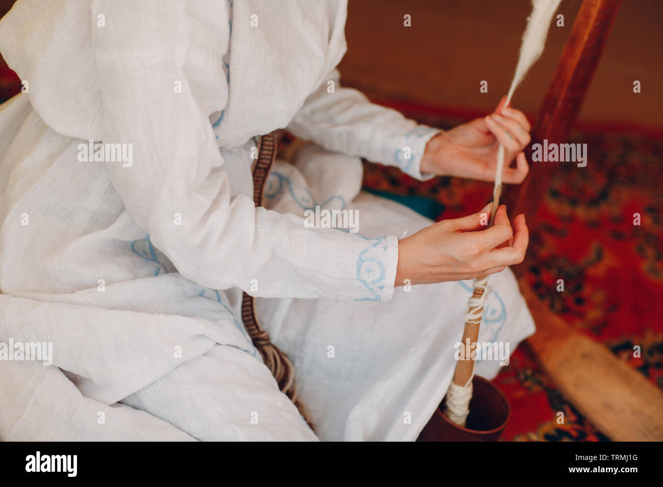 Woman makes thread, yarn and fabric Stock Photo - Alamy