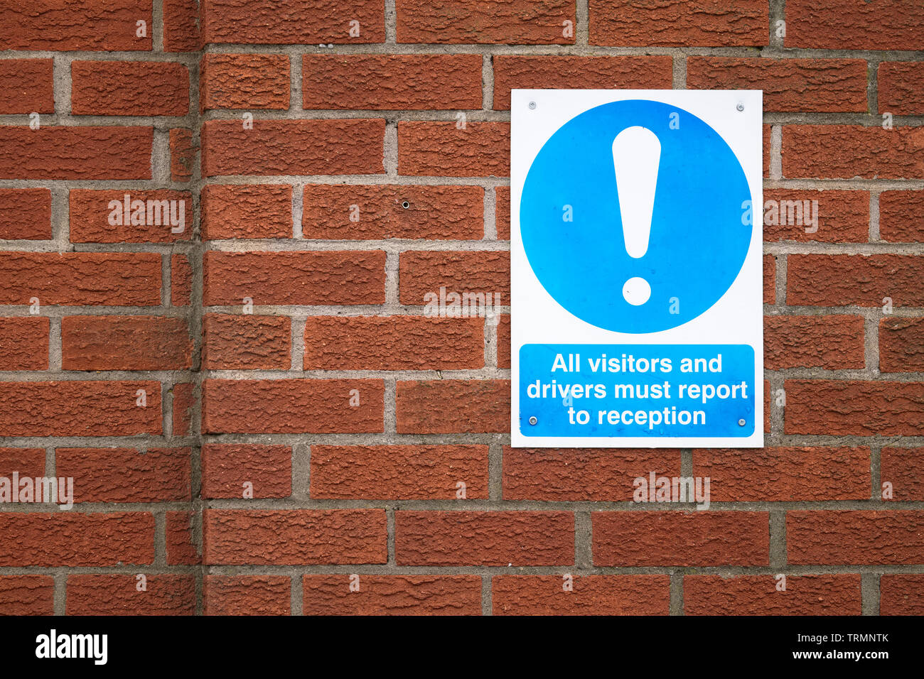 Visitors and drivers report to office reception sign Stock Photo - Alamy