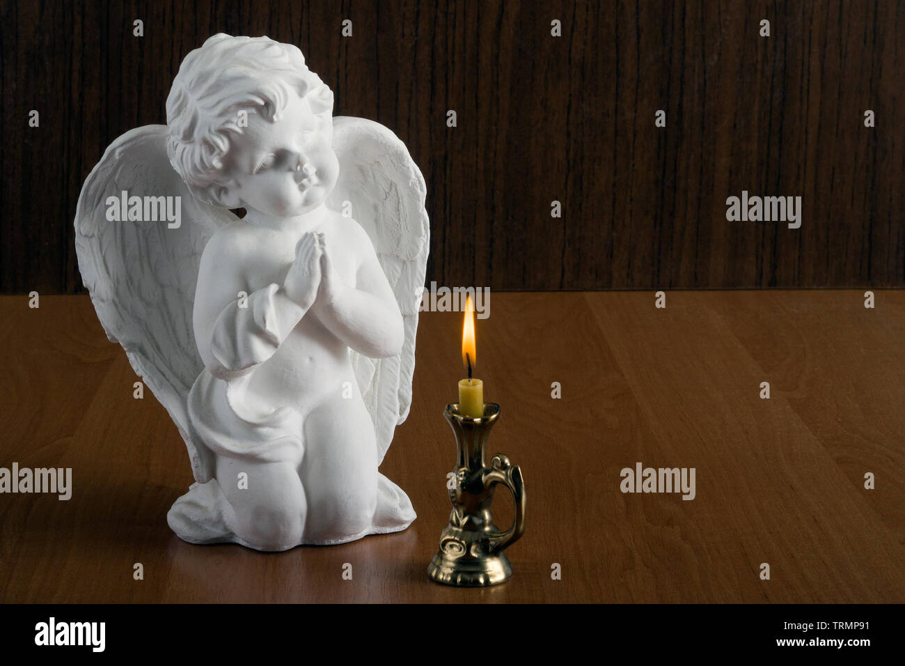 Angel. Guardian angel folded his hands in prayer. Wooden background ...