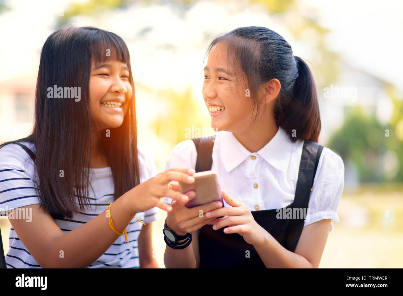 two asian teenager laughing with happiness face reading message in ...