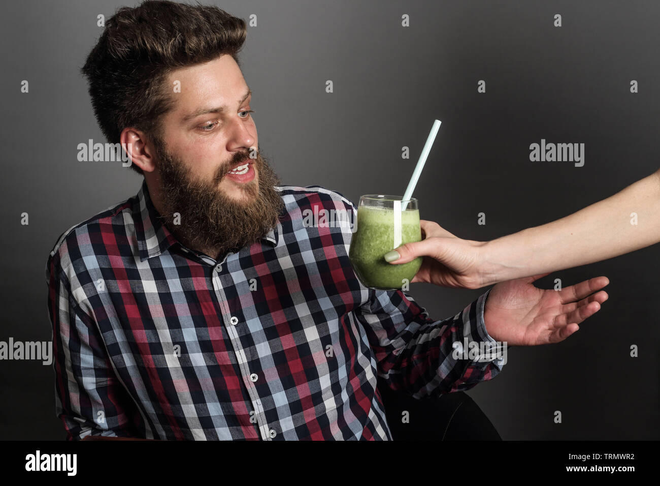 Young Man looks incredulously at woman giving him healthy eating green ...