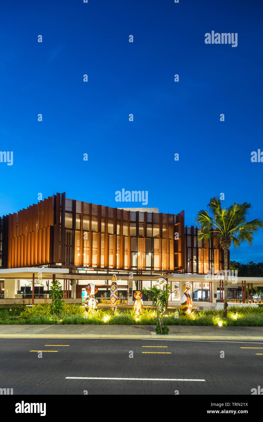 The facade of the Cairns Performing Arts Centre illuminated at twilight ...