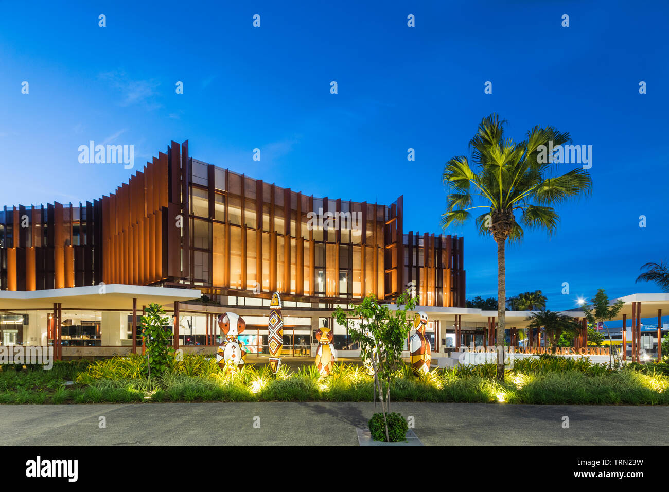 The facade of the Cairns Performing Arts Centre illuminated at twilight ...