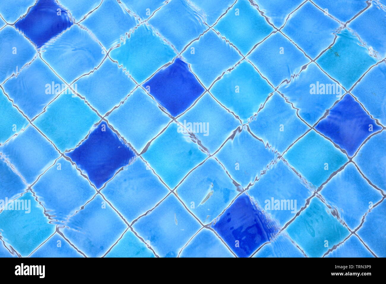 swimming pool ceramic tiles covered in clear water. light blue tiles ...
