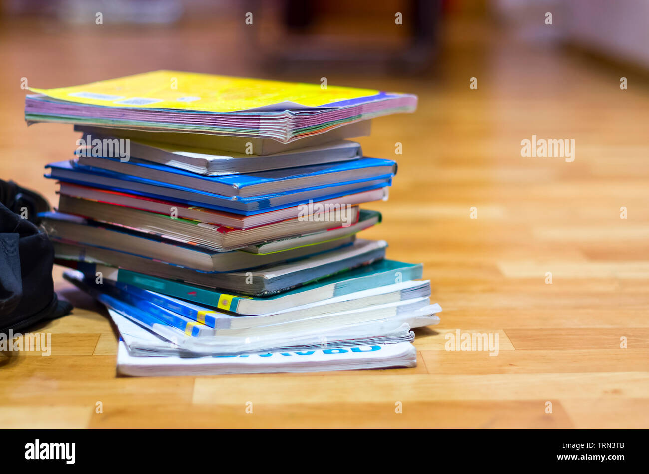 Stack of Textbooks and Black Backpack on Wooden Floor. Education ...