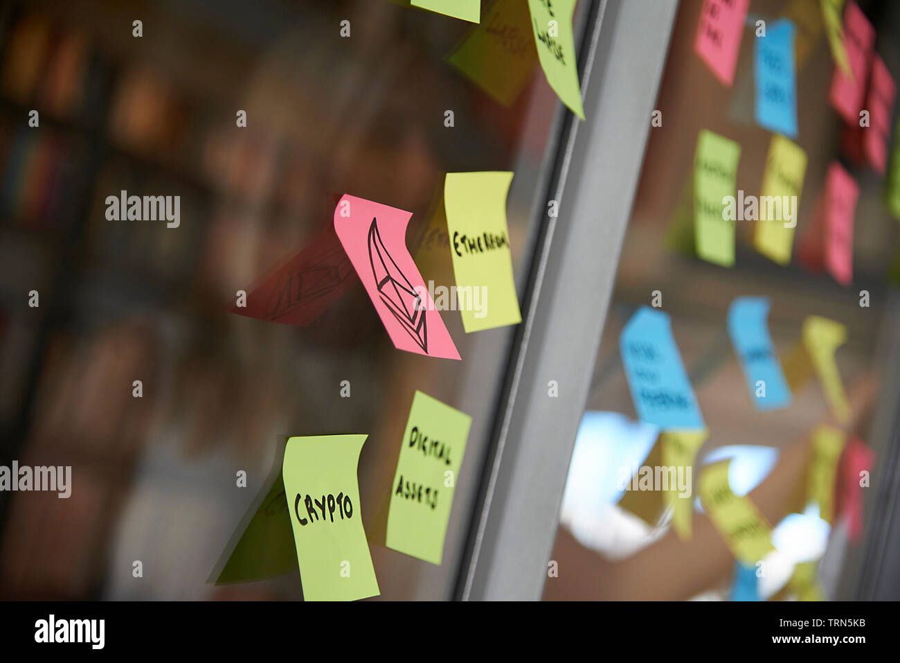A woman organizing post-it notes on a window in the office making a ...