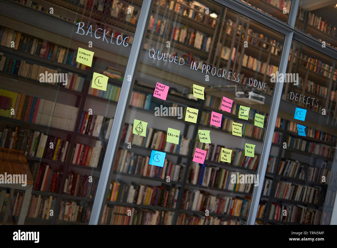 A woman organizing post-it notes on a window in the office making a ...