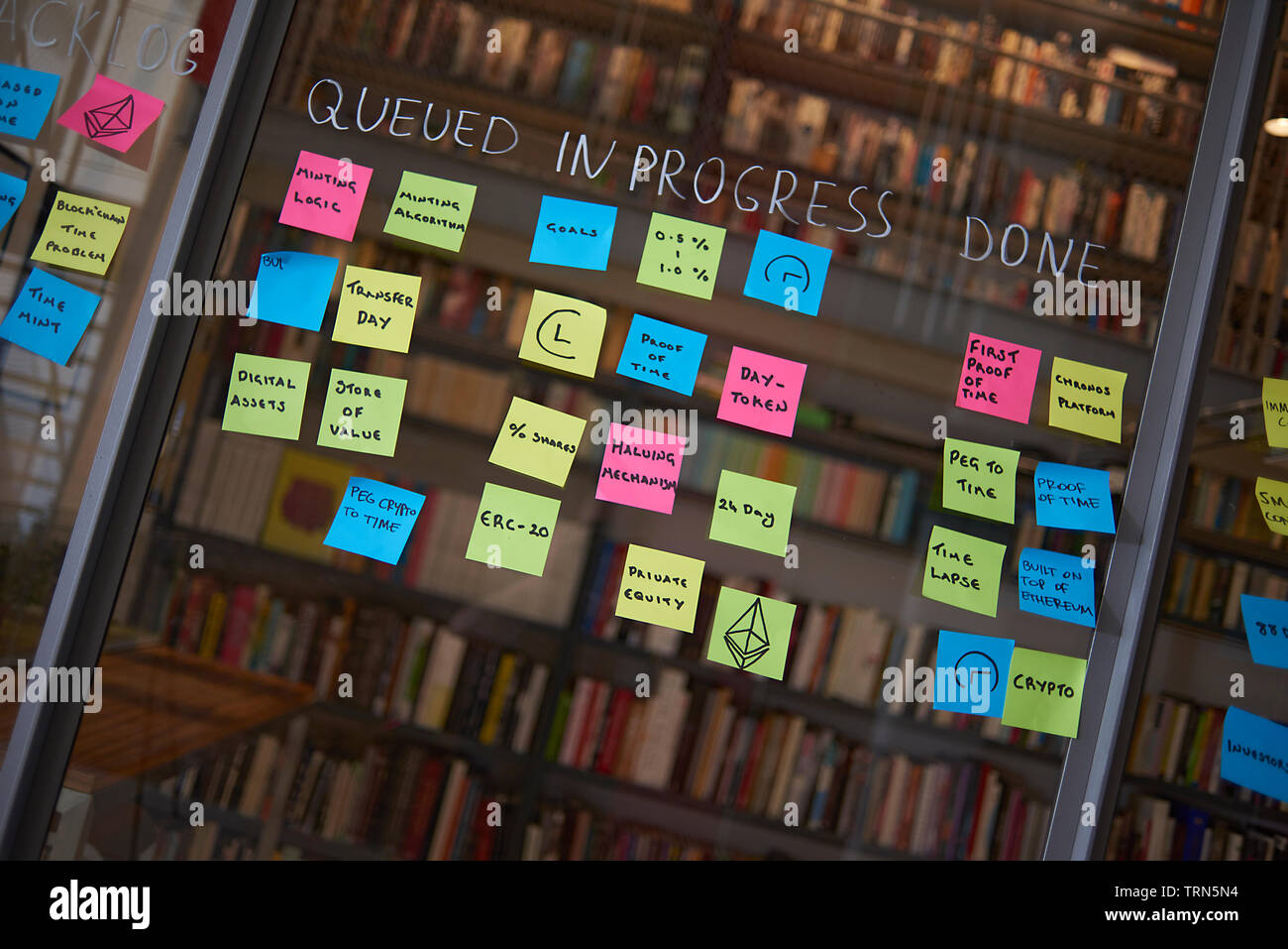 A woman organizing post-it notes on a window in the office making a ...