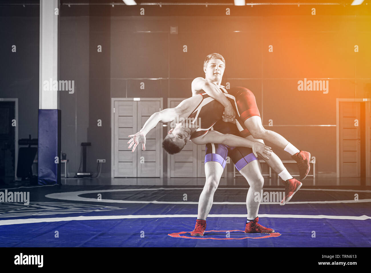 Two young men in blue and red wrestling tights are wrestlng and making ...