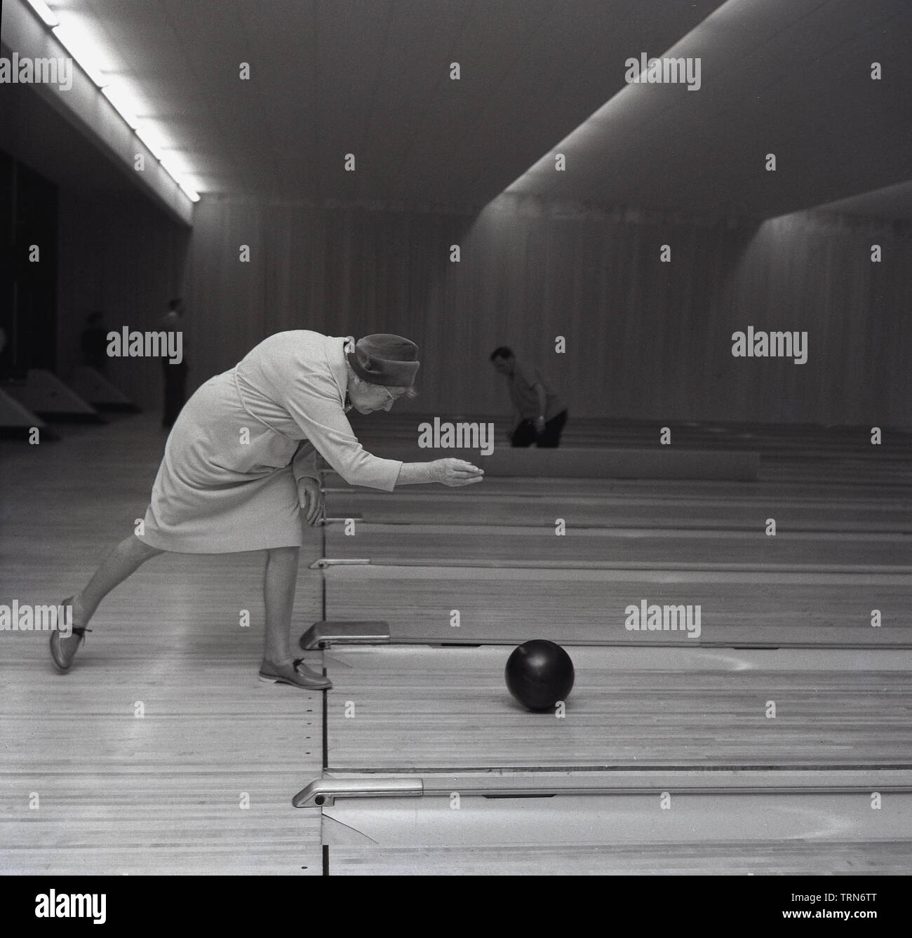 1967, historical, elderly lady bowling a ball at a ten-pin bowling ...