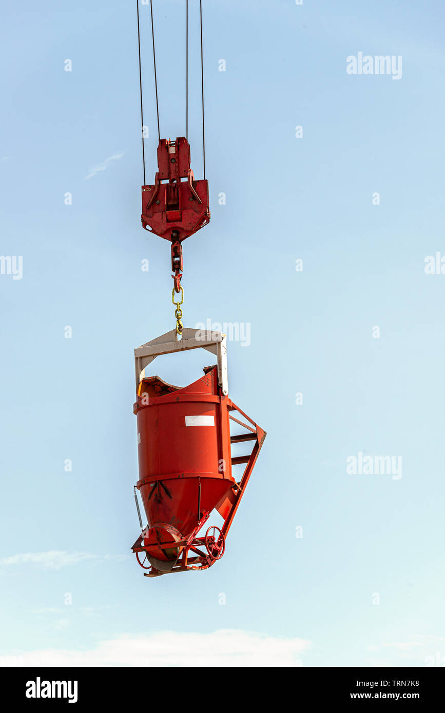 orange cement cistern hanging with a steel hook on the pulleys of a ...