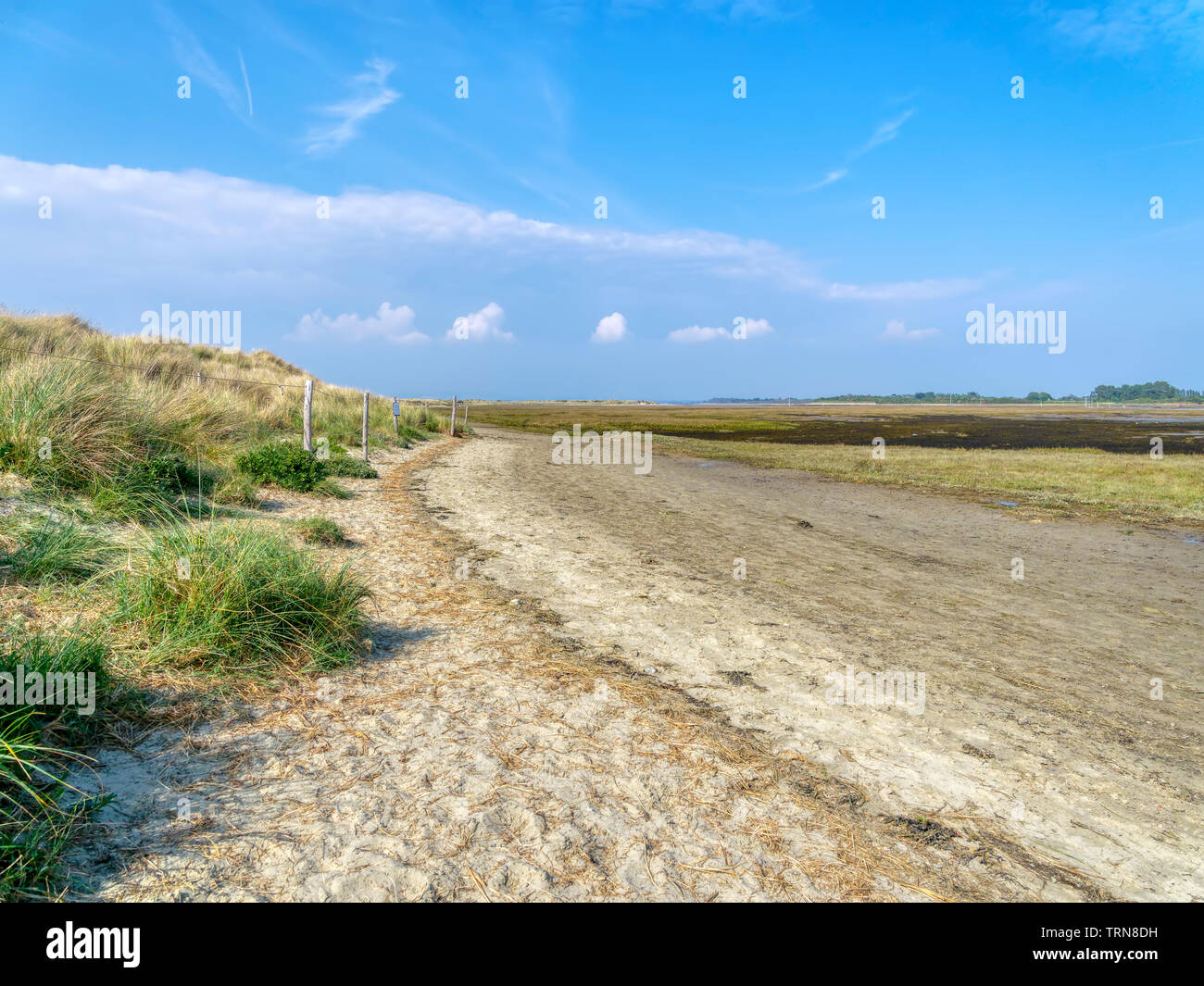 A footpath at the bottom of sand dunes leading around West Wittering ...