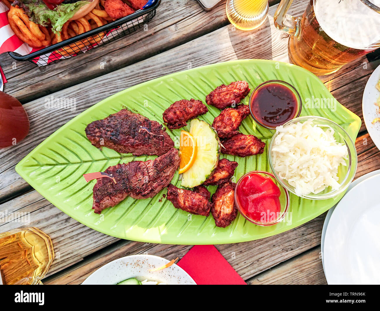 Beef steak with chicken wings and fruits, top view Stock Photo - Alamy