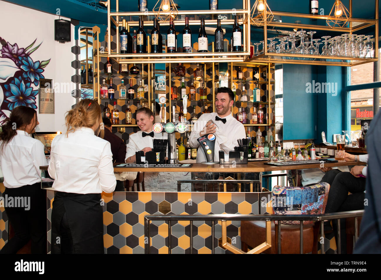 Doncaster, UK - May 11 2019: Barman and waitresses share a joke while ...