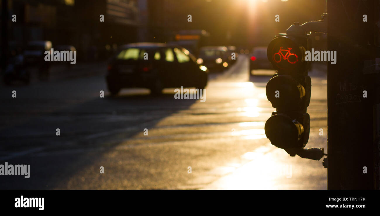 Red bicycle traffic light with cars, traffic in the background during ...