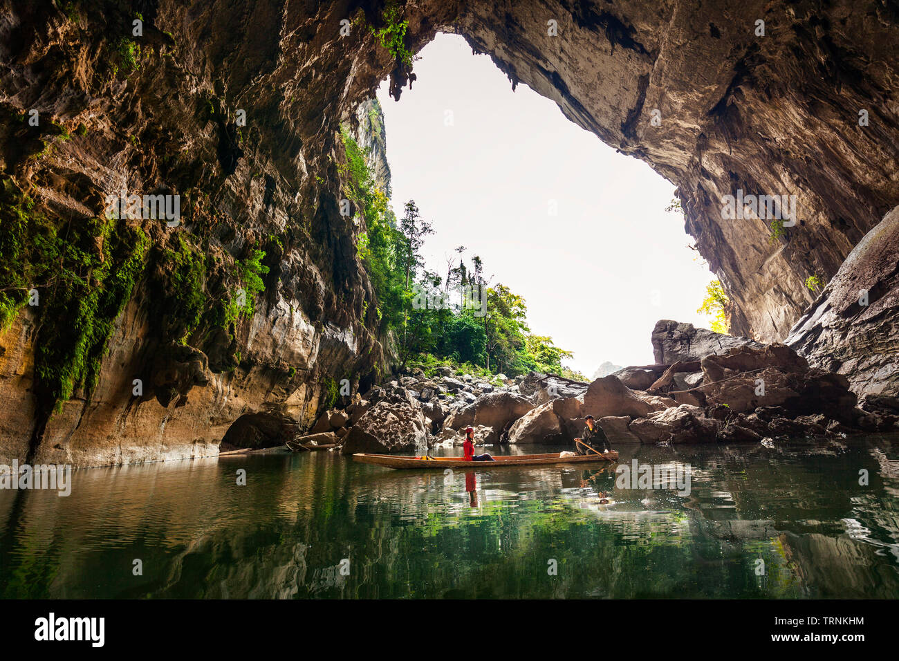 Entrance with boat and tourist with guide, Xe Bang Fai river cave, Laos ...