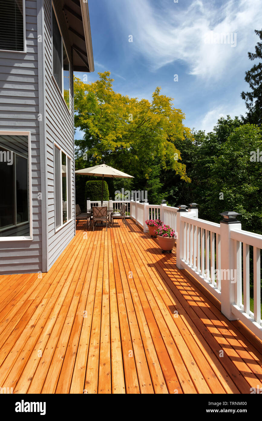 Brand new red cedar outdoor wooden deck during nice weather in vertical ...