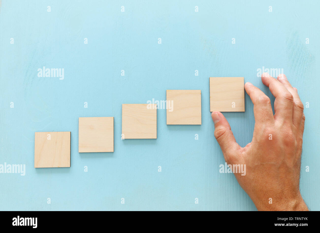 Hand arranging wood block stacking as chart or ladder. concept for ...