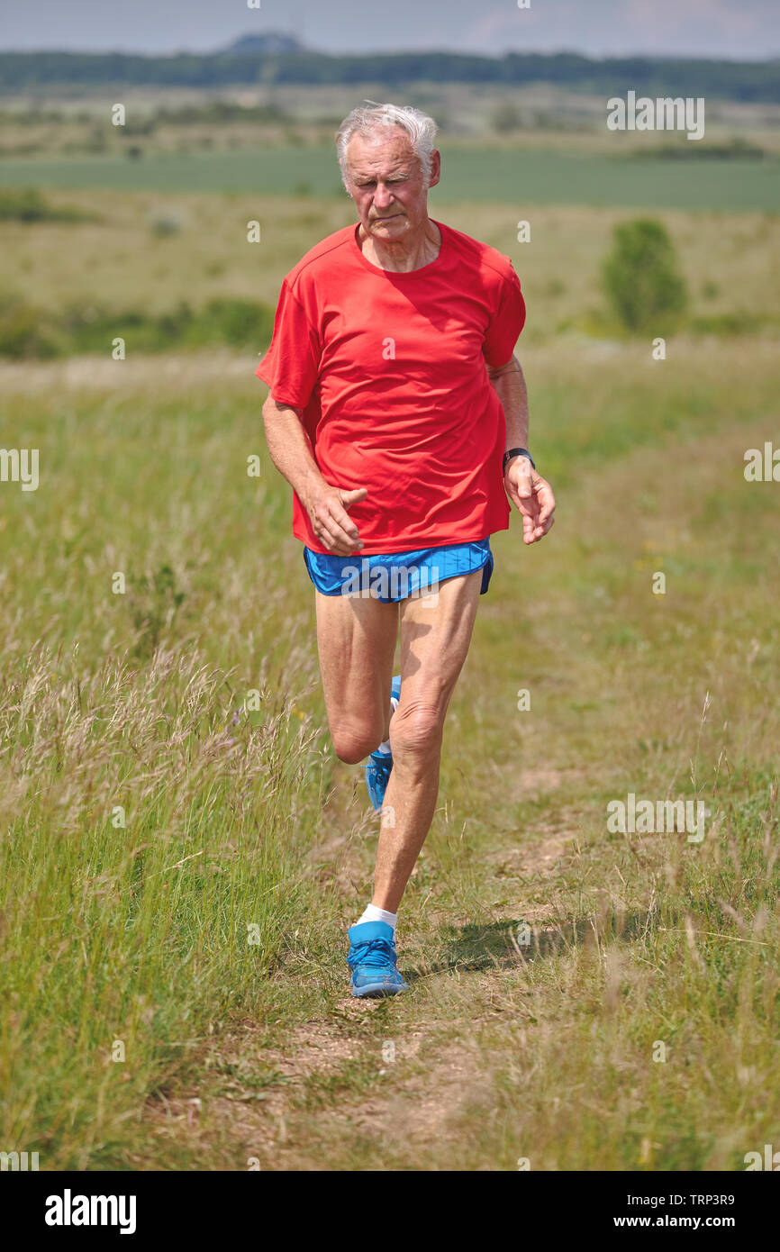 Senior runner running on the meadow at springtime Stock Photo - Alamy