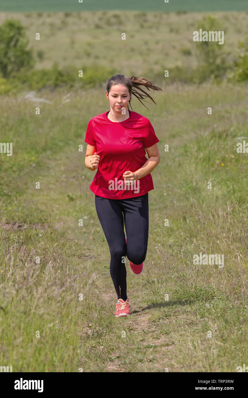 Young pretty girl running on the meadow Stock Photo - Alamy