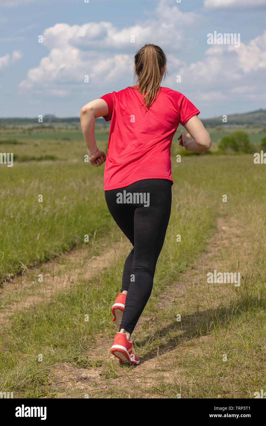 Young pretty girl running on the meadow Stock Photo - Alamy
