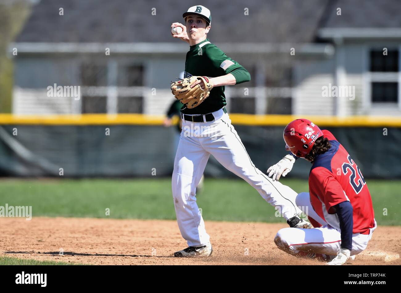 After retiring a sliding runner at second, a second baseman relays to ...