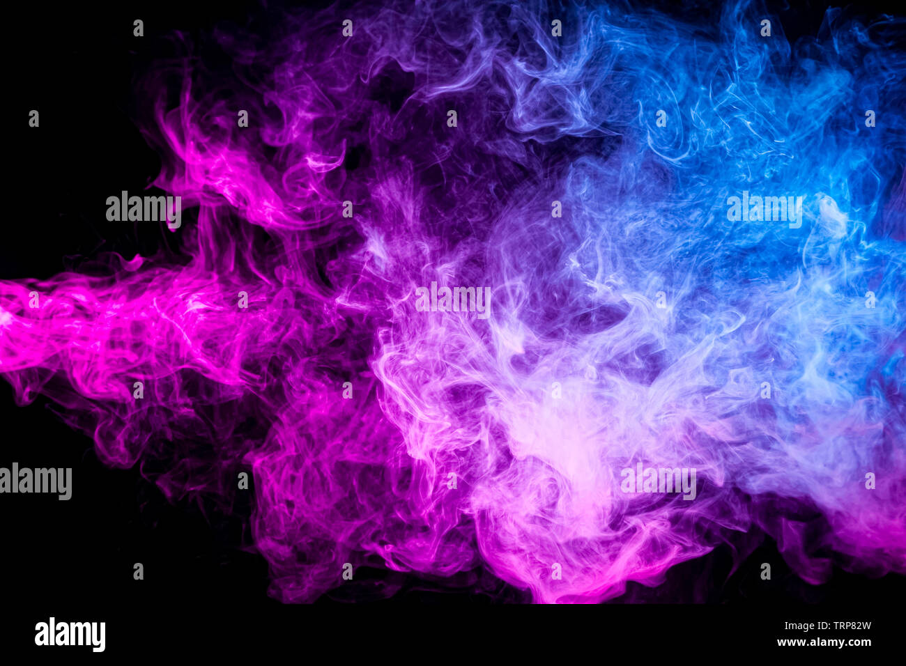 Close up swirling pink and blue smoke on black isolated background ...