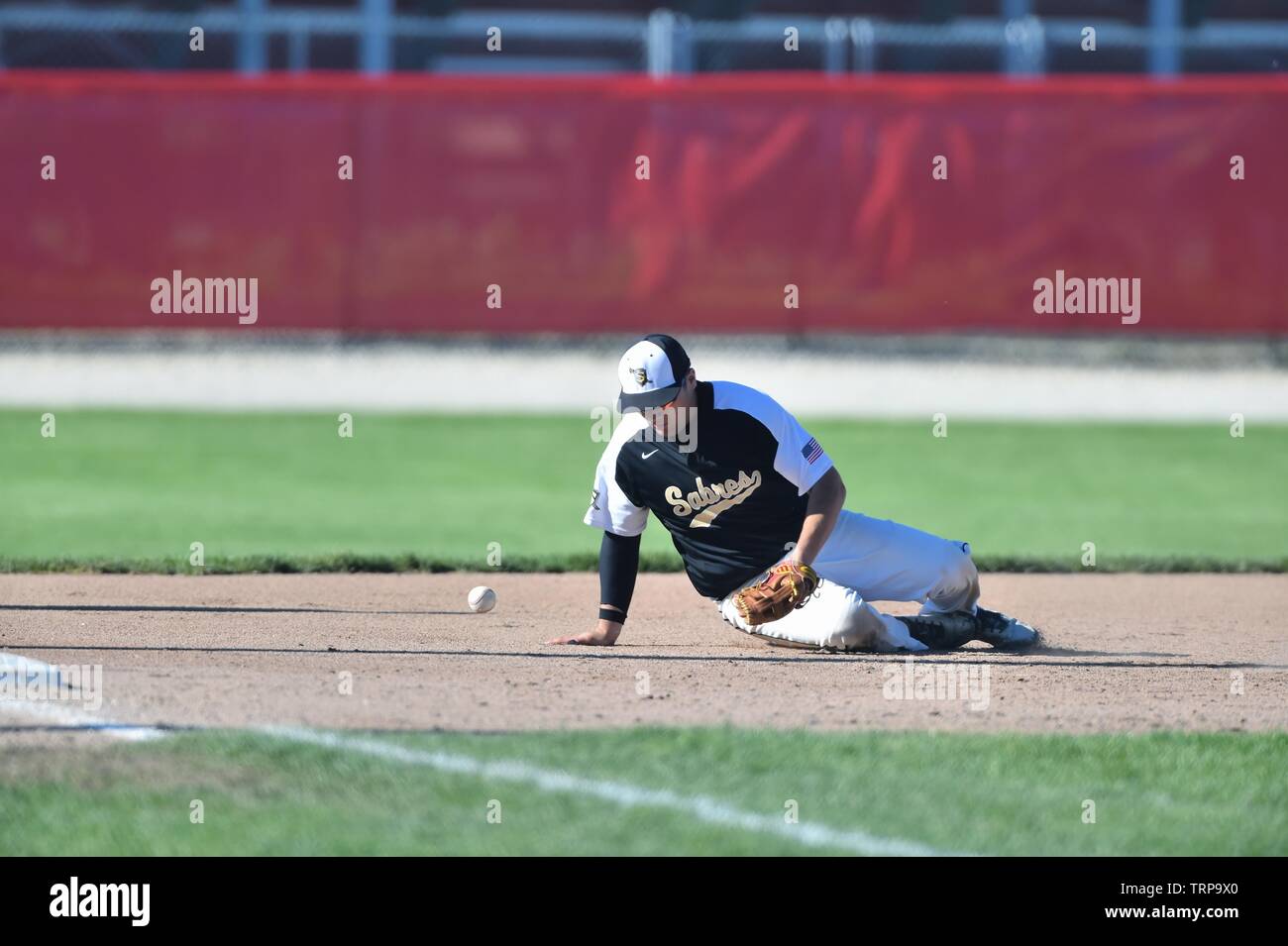 Third baseman handcuffed by a ground ball and unable to keep the batter ...