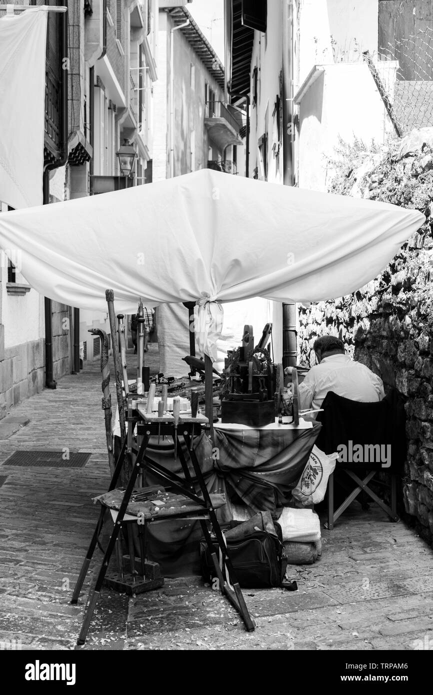 Man sitting at his market stall working Stock Photo - Alamy
