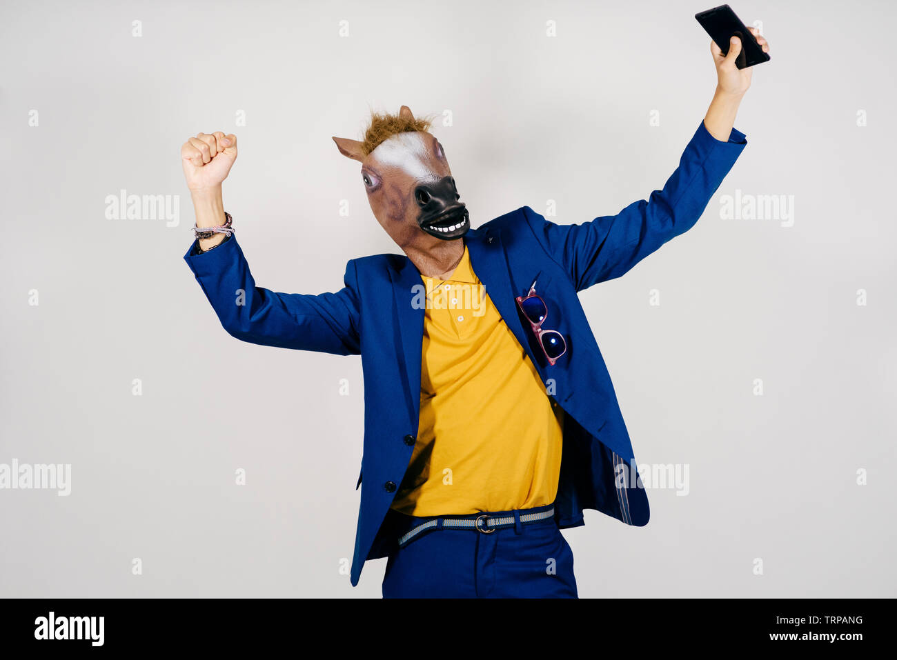 Unrecognizable man disguised with a horse head and dressed with a blue ...