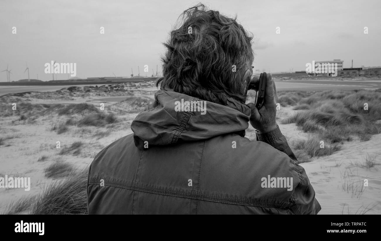 Man handling a mobile phone while walking in the Sand dunes, Boulogne ...