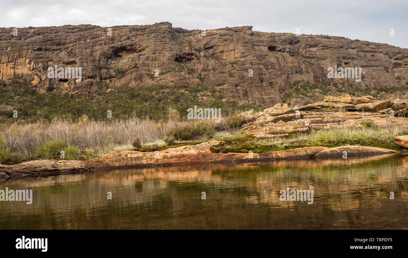Landscape of ancient sandstone mountain range with pond in foreground ...