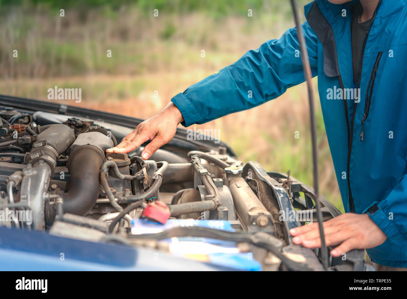 Asian stressed man having trouble with his broken car looking in ...