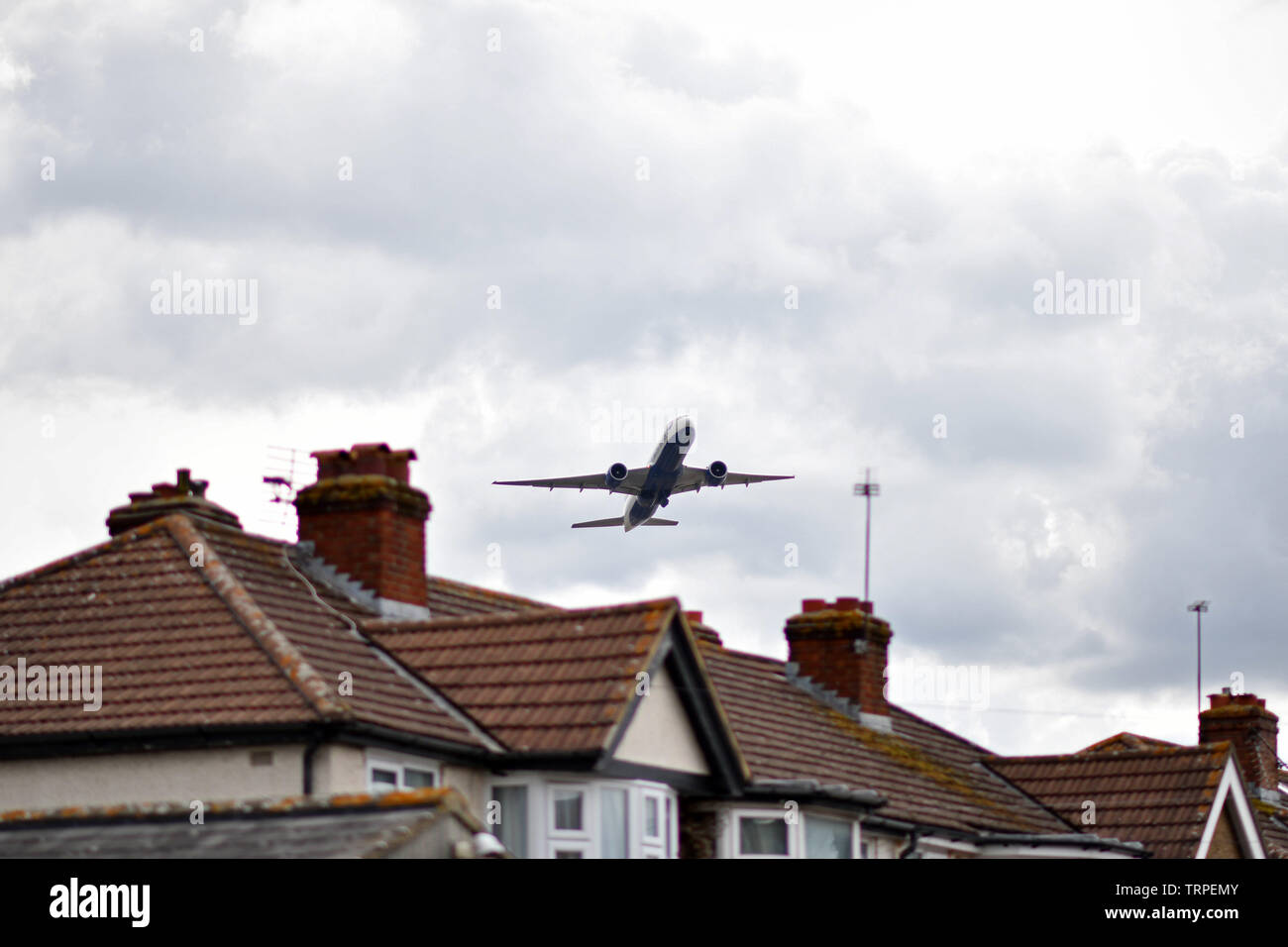 Plane flying over houses heathrow hi-res stock photography and images ...