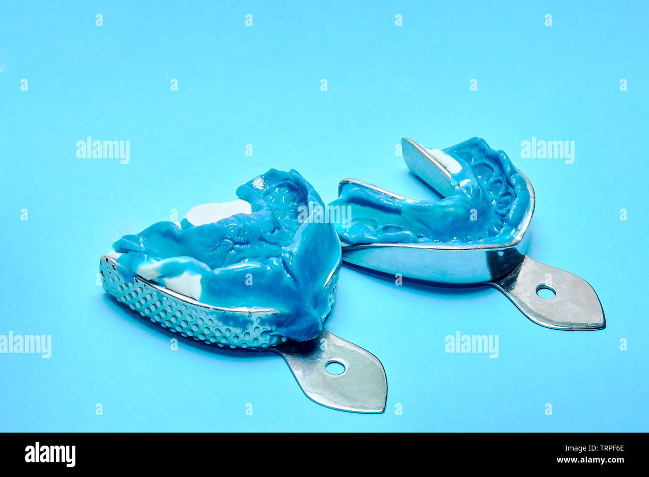 Two dental impressions on a blue background. Dental molds from the ...