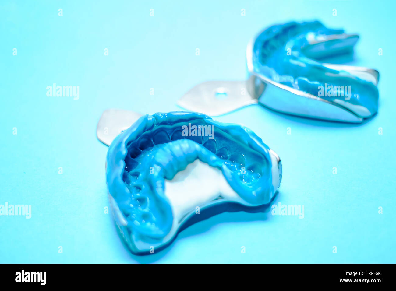 Two dental impressions on a blue background with copy space. Dental ...