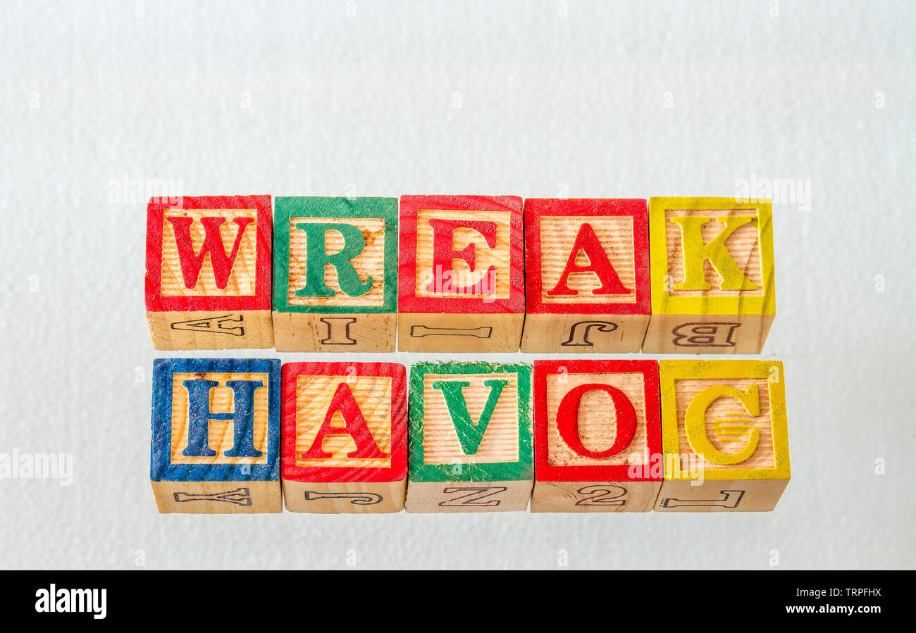 The term wreak havoc visually displayed using wooden blocks on a clear ...