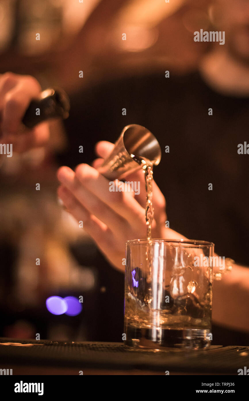 Close up shot of a bartender pouring a drink in a glass Stock Photo - Alamy