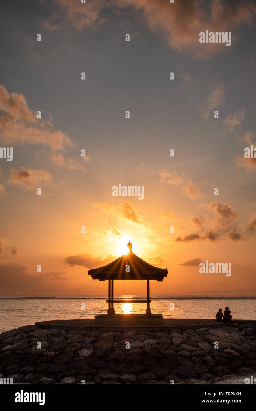 Sunshine over pavilion on jetty at coastline in morning. Sanur beach ...