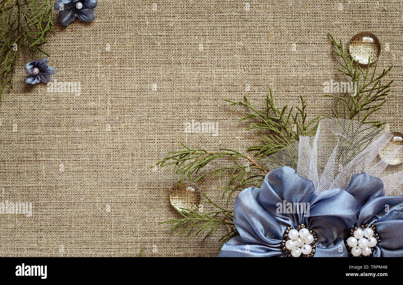 Canvas background with handmade flowers and evergreen twigs in corners ...