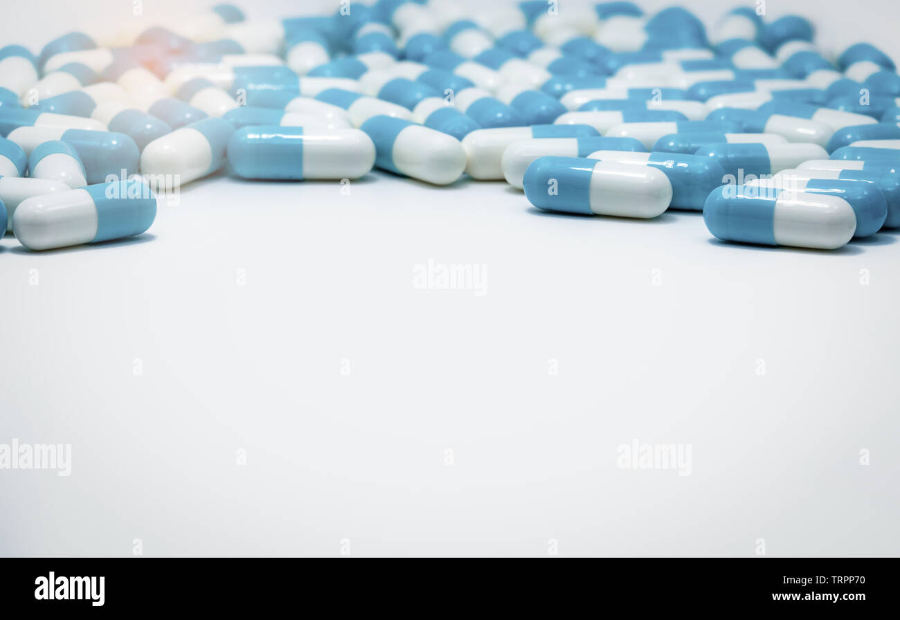 Blue and white capsule pills on white background. Antibiotics drug ...