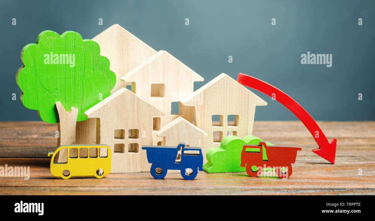 Wooden houses and red arrow down. Falling demand and real estate prices ...