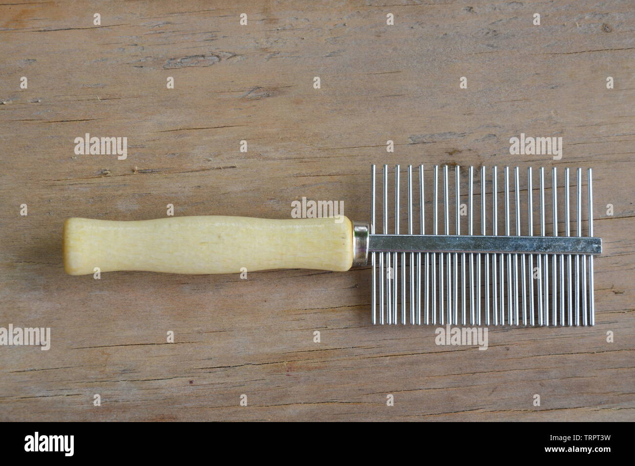 comb with teeth away and fine side for dog and cat on wooden board ...