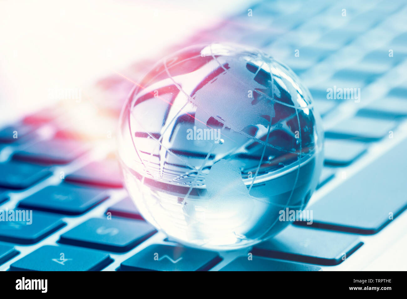 Global computer business concept with small globe on laptop keyboard ...
