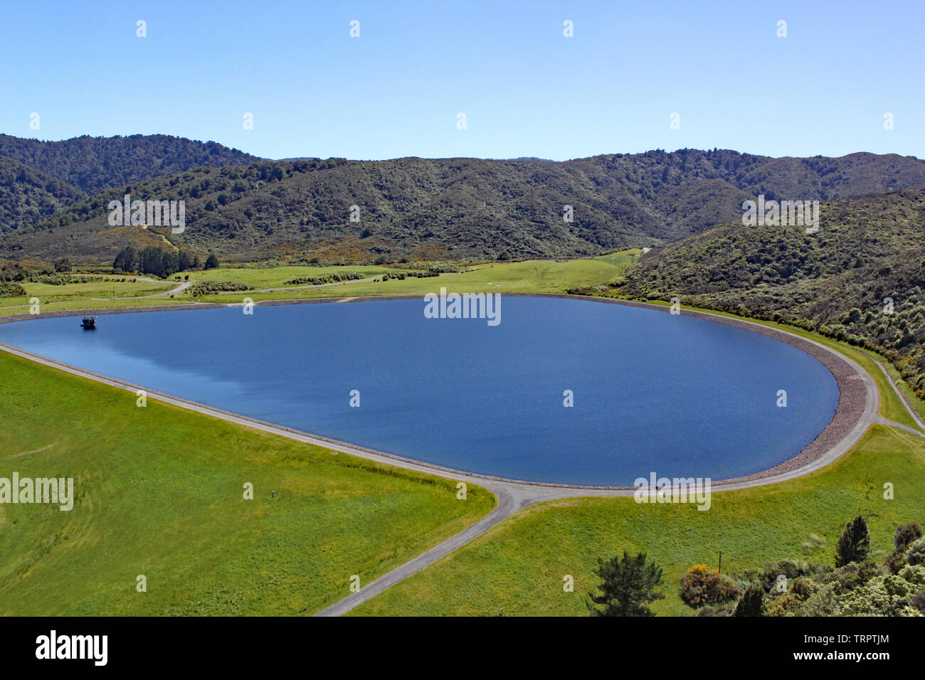 Clear blue reservoir set in the hills in North Island, New Zealand ...