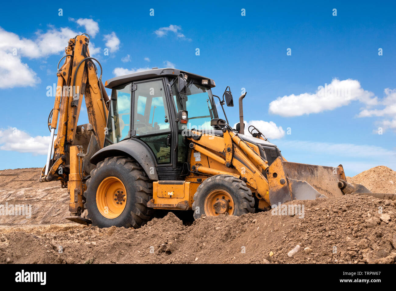 Wheel loader excavator works in construction site quarry under blue sky ...
