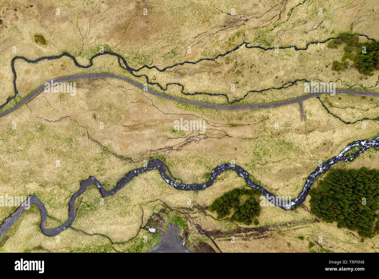 Aerial view of winding small river, stream in green field in Iceland by ...