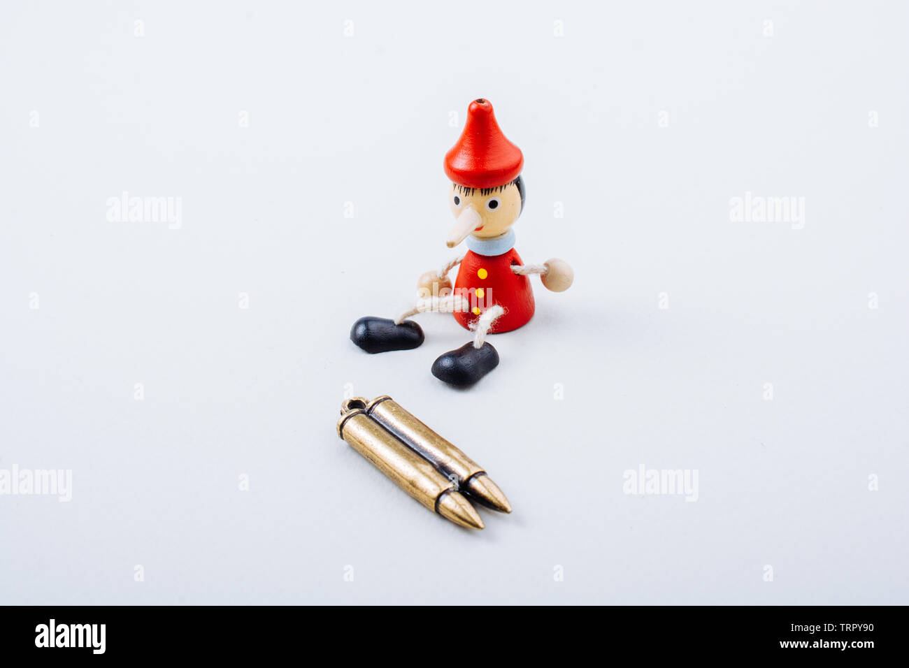 Bullet and wooden pinocchio doll with his long nose Stock Photo - Alamy